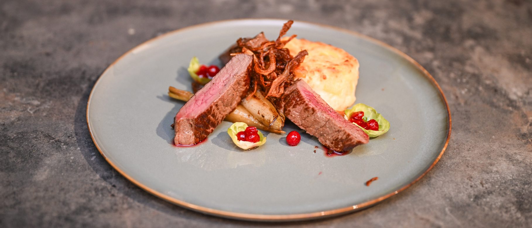 Steak de cerf avec gratin dauphinois, légumes d'hiver et canneberges