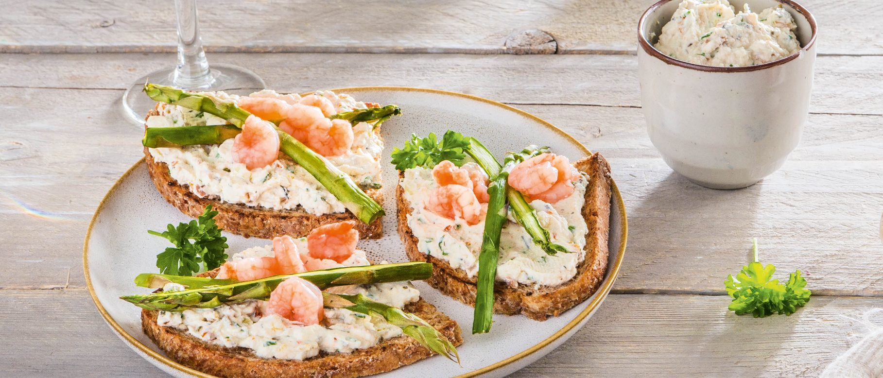 Toast mit Ricotta-Kräuteraufstrich, grünem Spargel und Garnelen